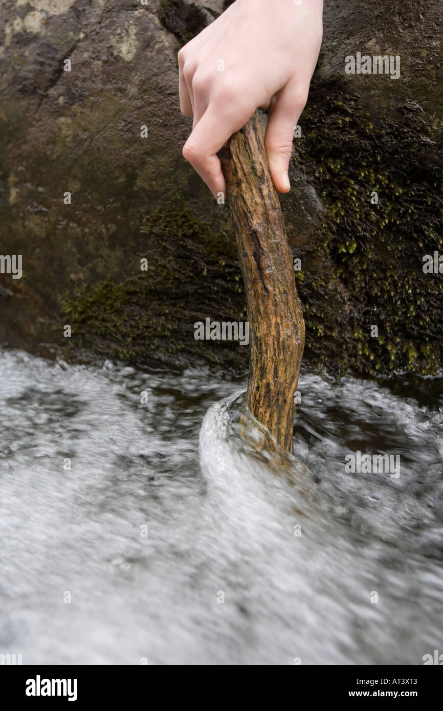 Hand holding a stick in flowing water Stock Photo - Alamy