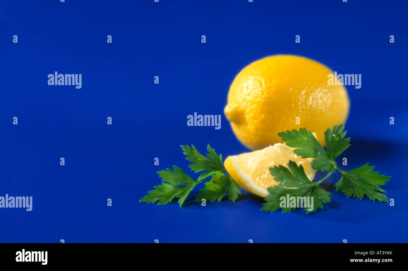 A whole and quarter lemon with flat leaf parsley Stock Photo - Alamy