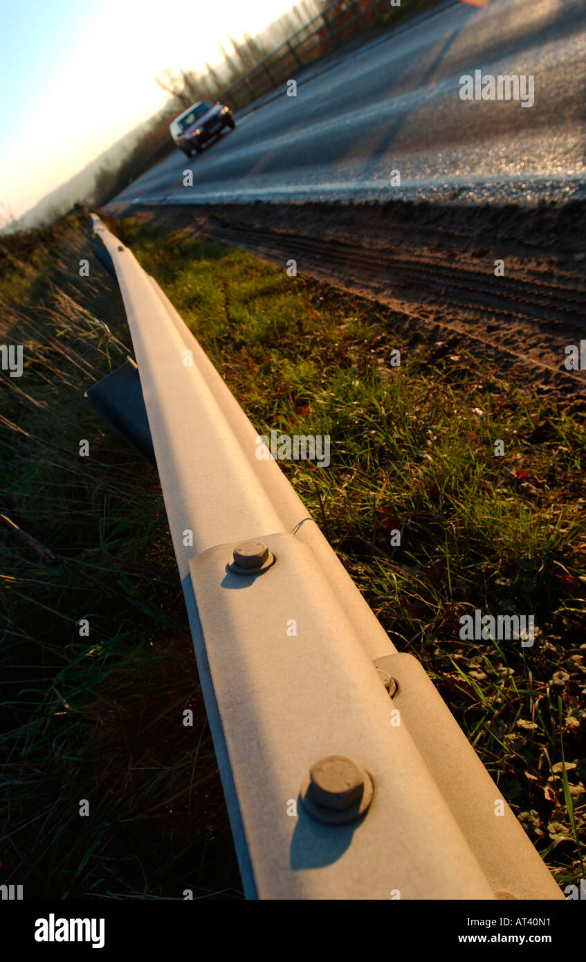 Roadside crash barrier with car in distance Stock Photo - Alamy