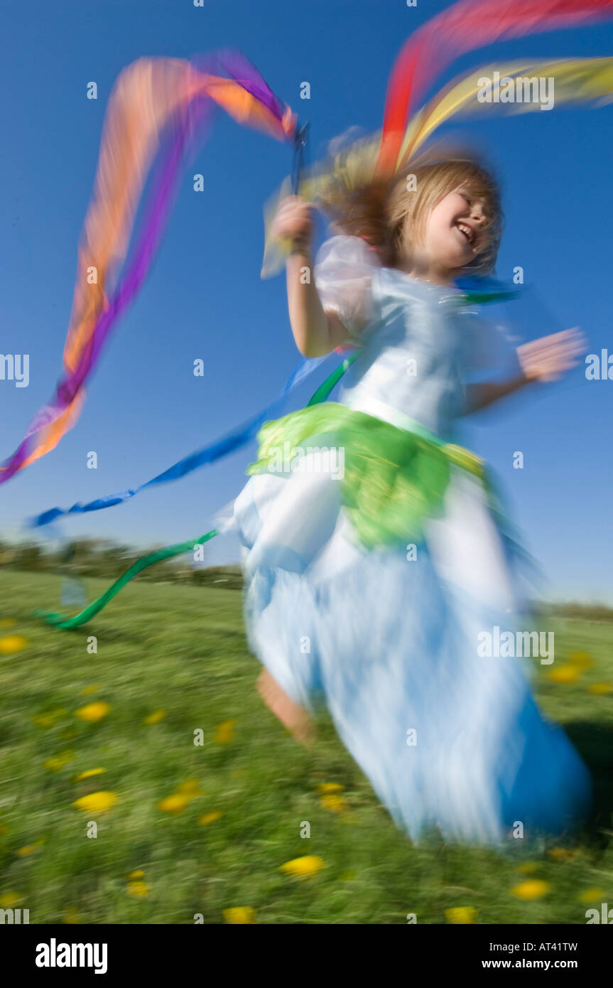 Child running in the grass with streamers Stock Photo - Alamy