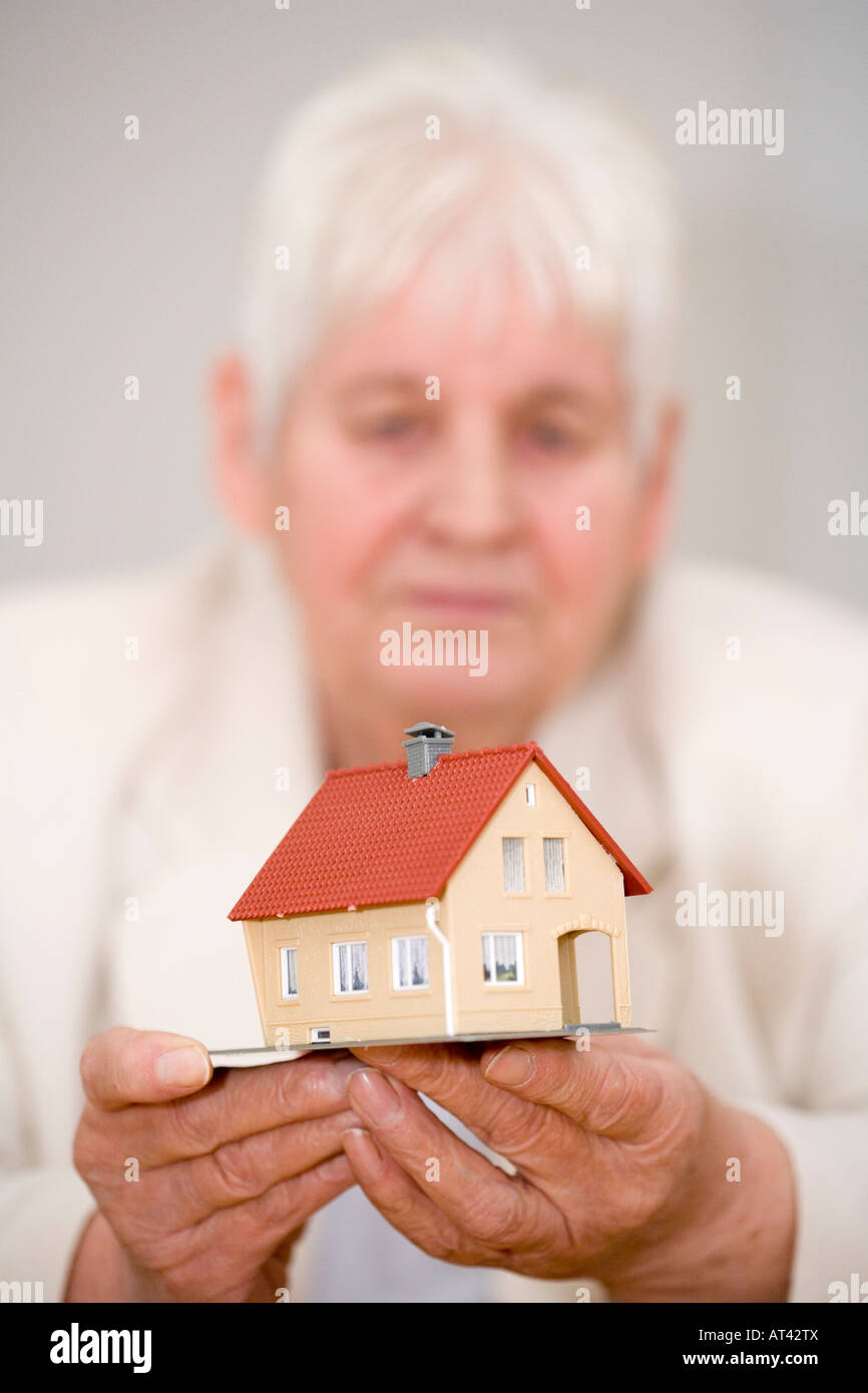 Senior woman with house model Stock Photo - Alamy