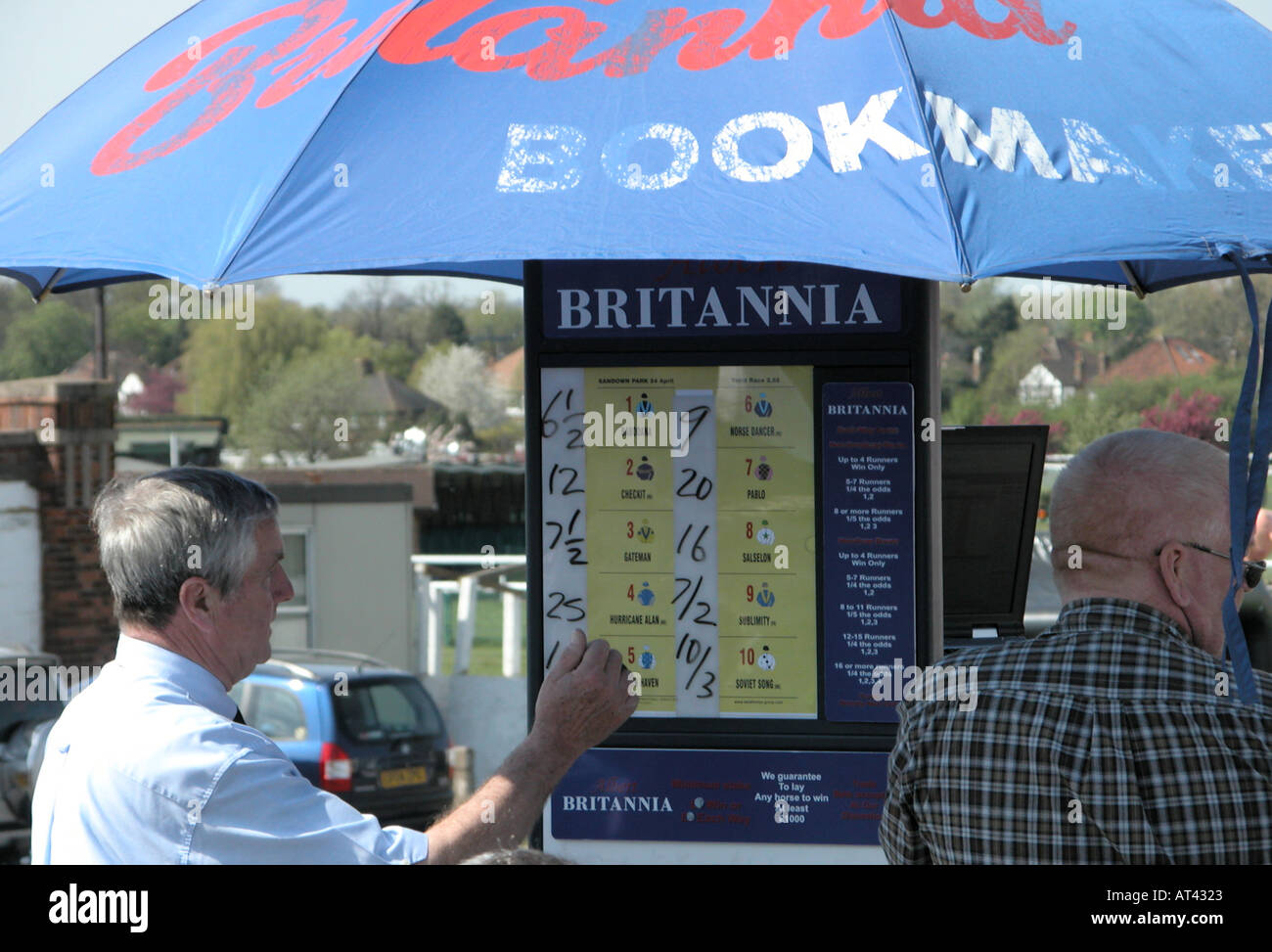 Bookmaker and his stand under an umbrella at Sandown Park UK Stock ...