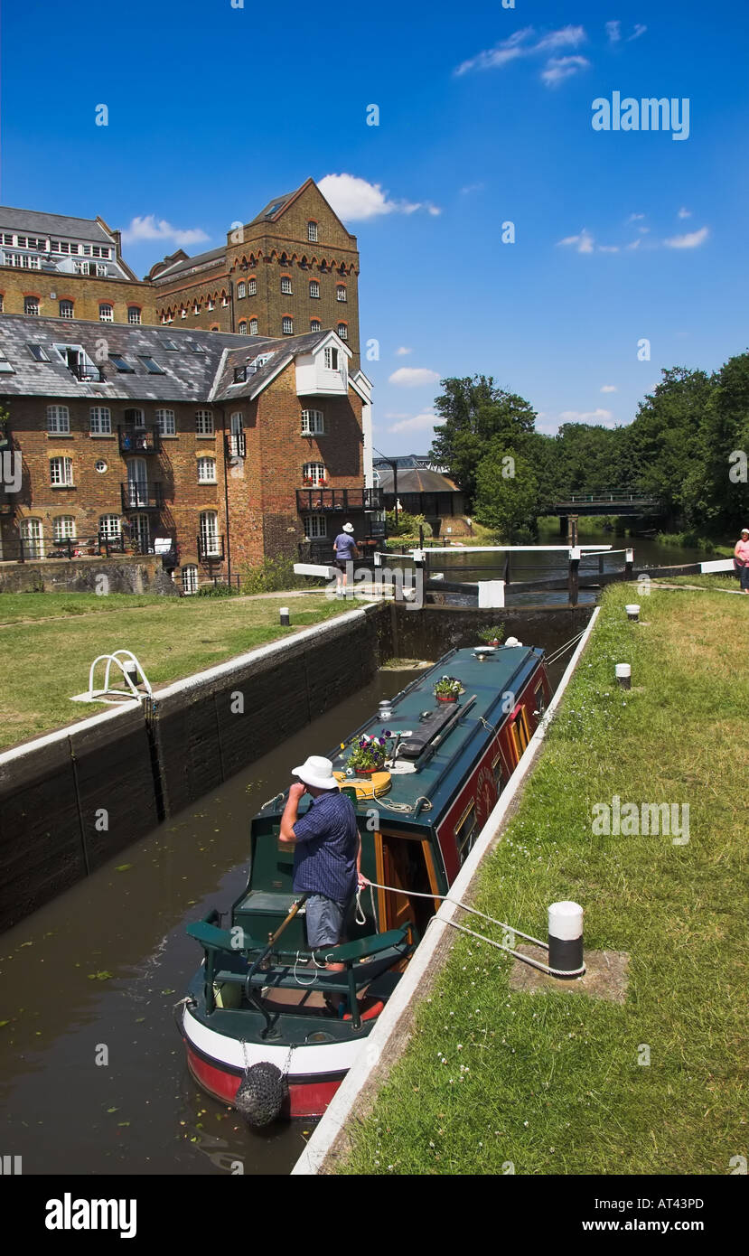 Narrowboat at Coxs Lock on the River Wey Navigation canal with old mill ...