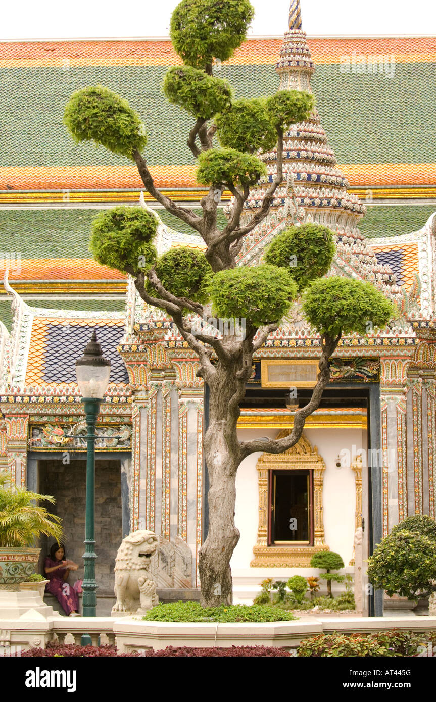 A decorative tree in front of colorful tile roofs on the grounds of the ...