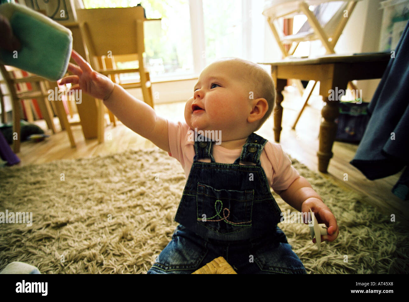 Infant reaching out for a toy Stock Photo - Alamy