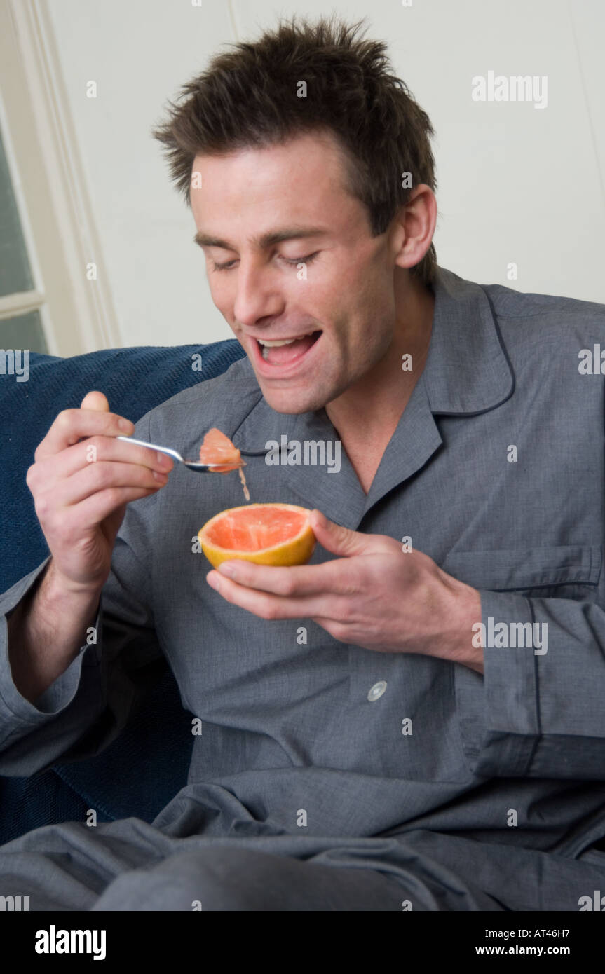 man eating a grapefruit for breakfast Stock Photo - Alamy