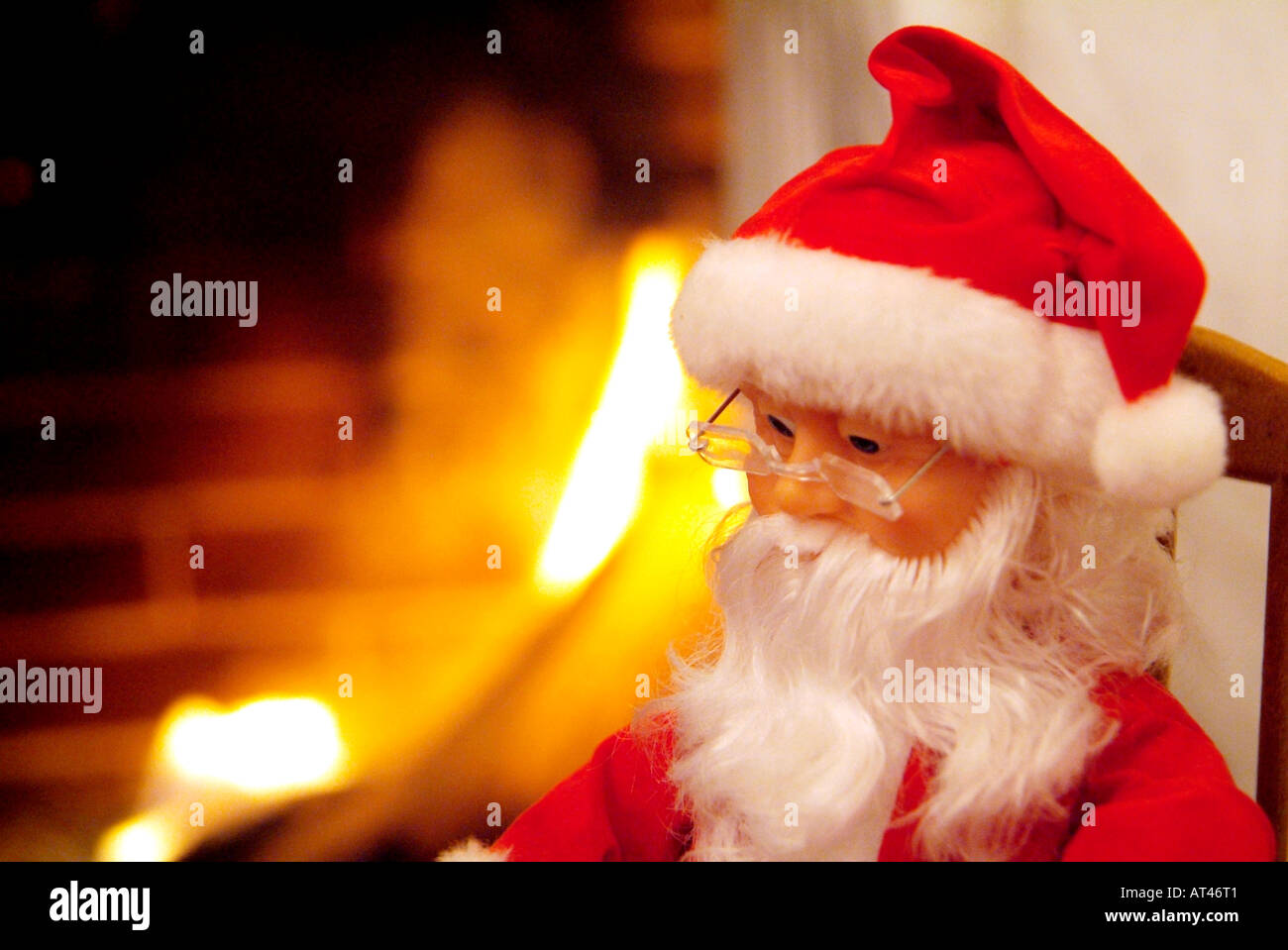 Santa Claus mannequin, sitting on a rocking chair next to the fireplace ...