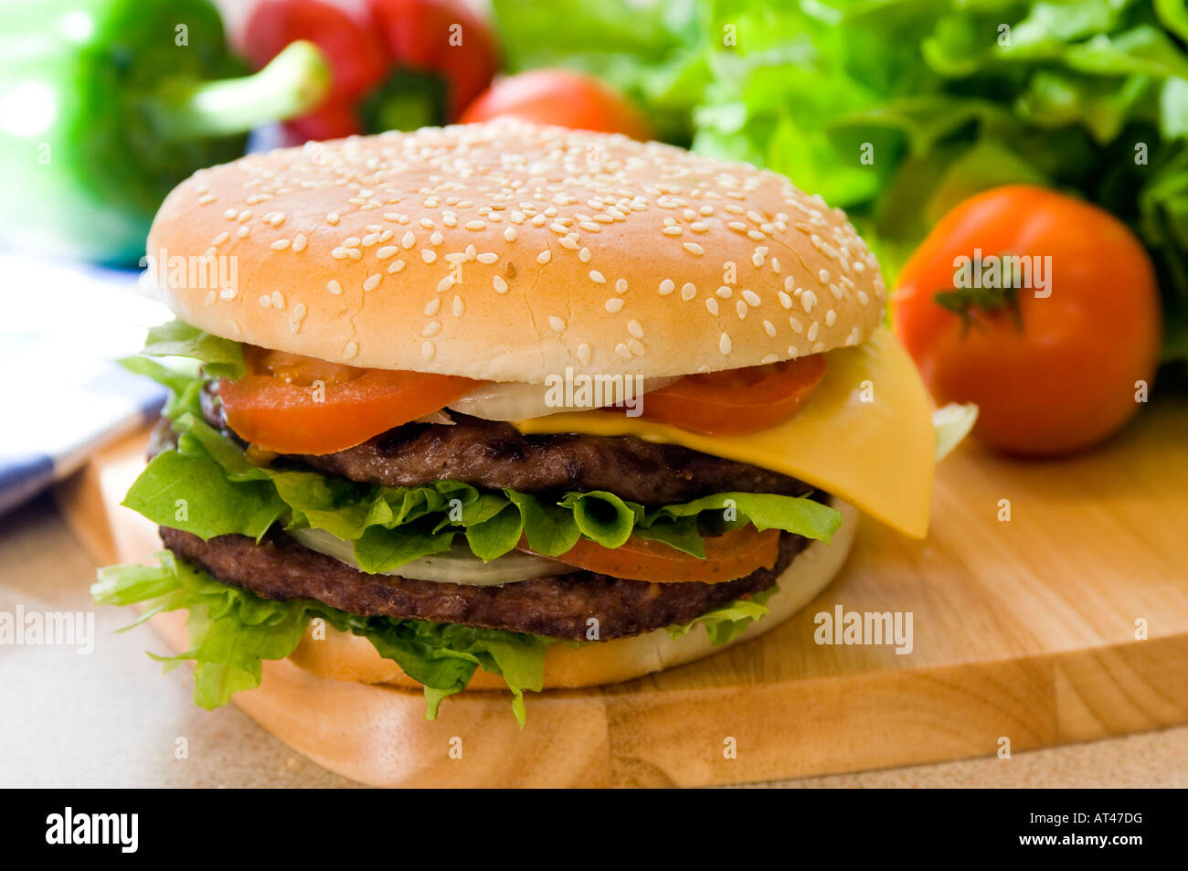 A hot double cheese burger with salad tomatoe & onions, presented with ...