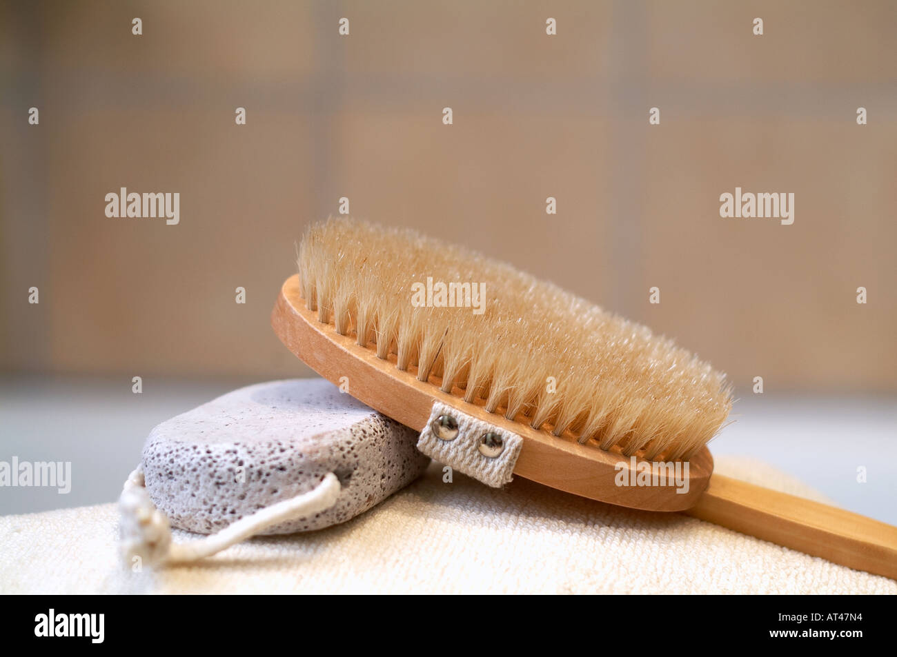 Bath brush and pumice stone on a towel Stock Photo - Alamy