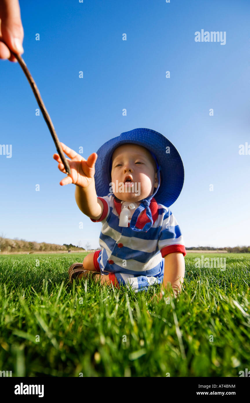 Toddler reaching for a stick Stock Photo - Alamy