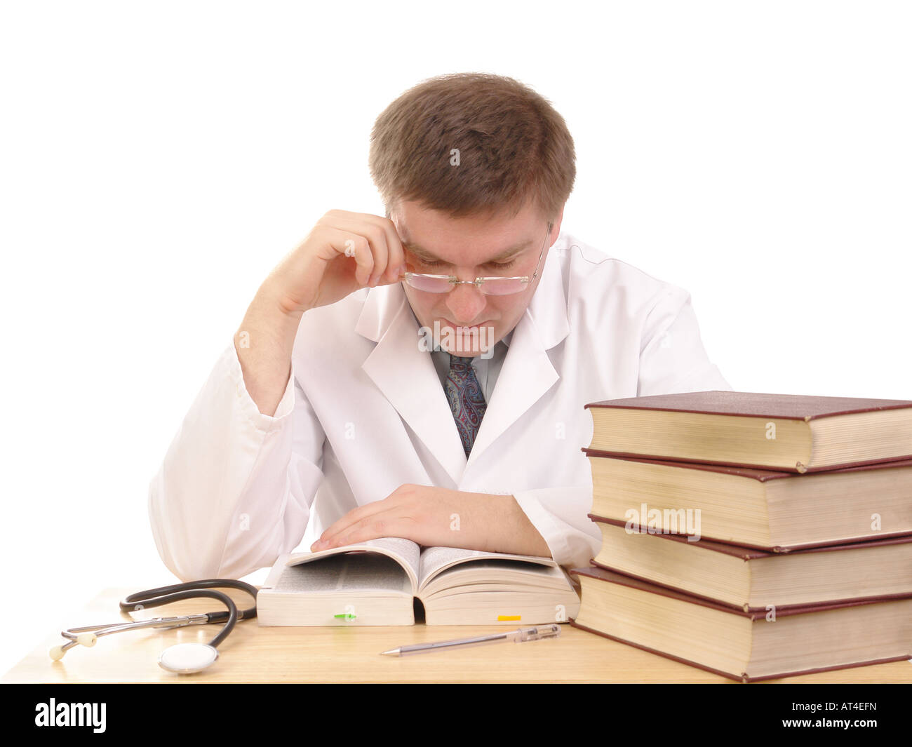 Young male doctor studying medical books - shot over white background ...