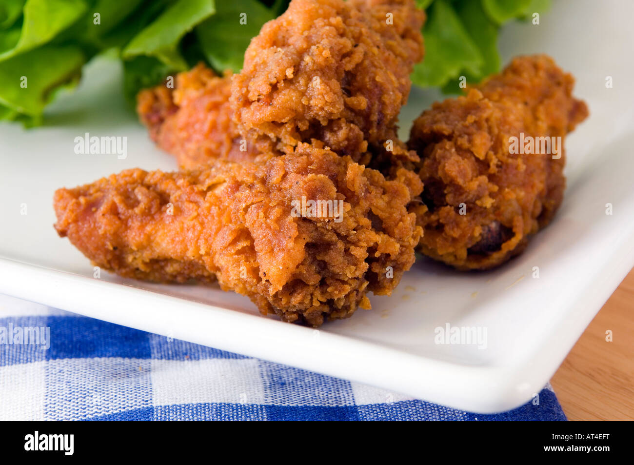 A plate with golden deep fried chicken wings displayed with a range of ...