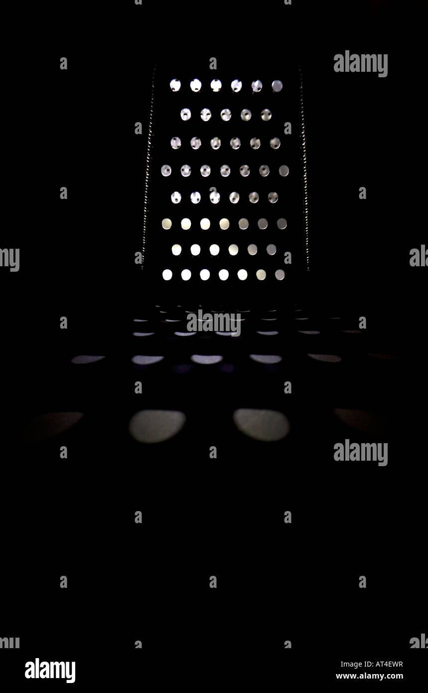 cheese grater in dark with lite from inside with light Stock Photo - Alamy