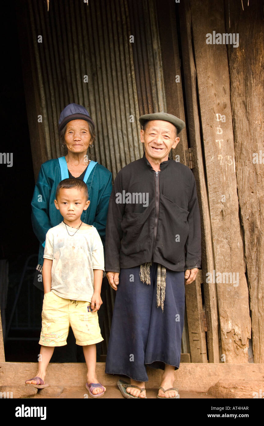 Woman man and boy outside a hut in the Hmong village Baan Pha Nok Kok ...