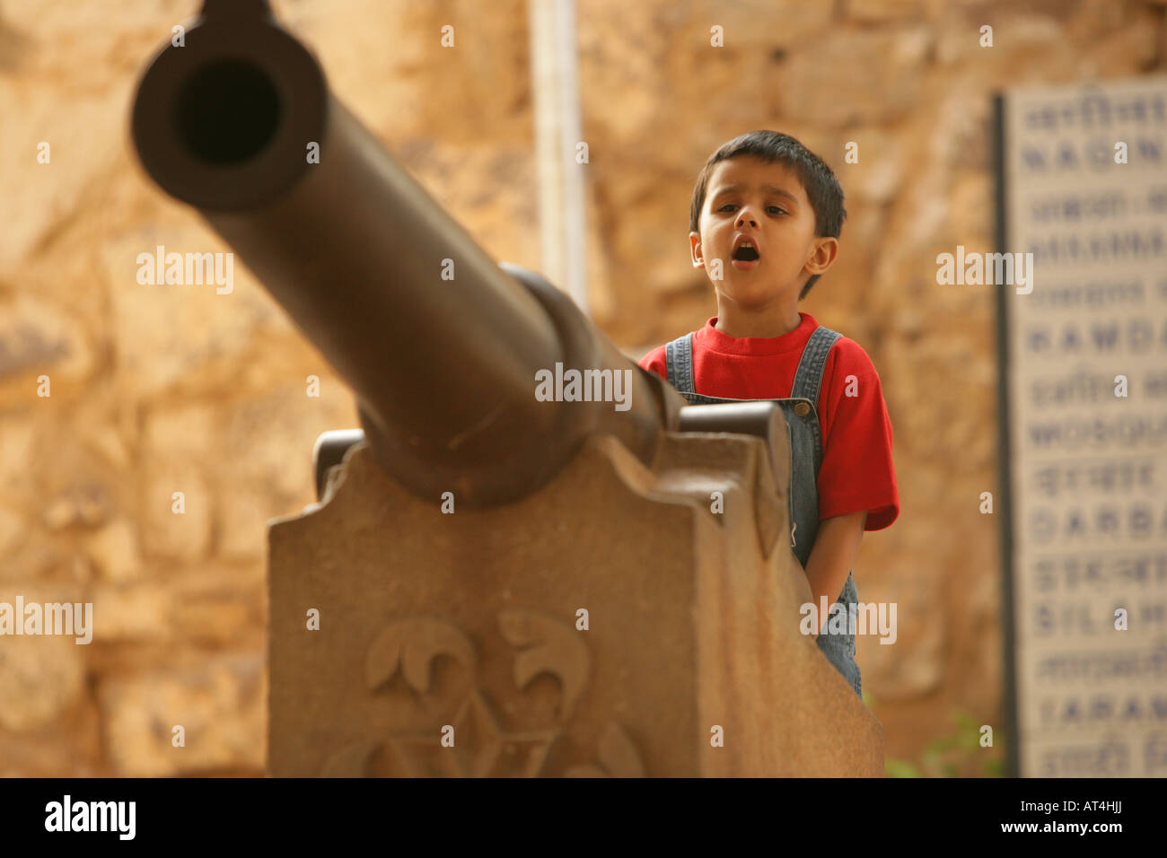 Young boy playing with a cannon at Golconda Fort in Hyderabad India ...