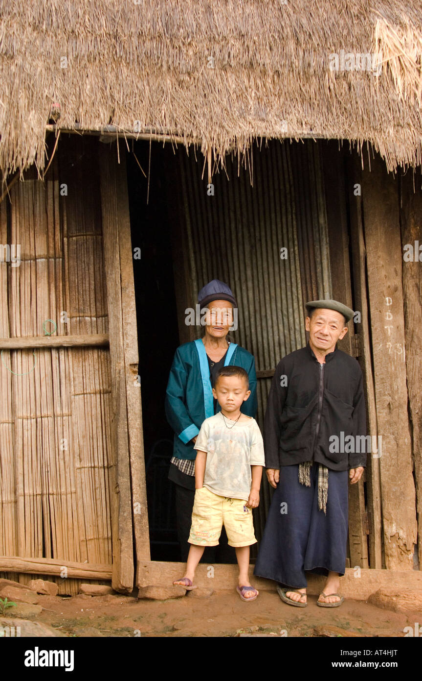 Woman man and boy outside a hut in the Hmong village Baan Pha Nok Kok ...