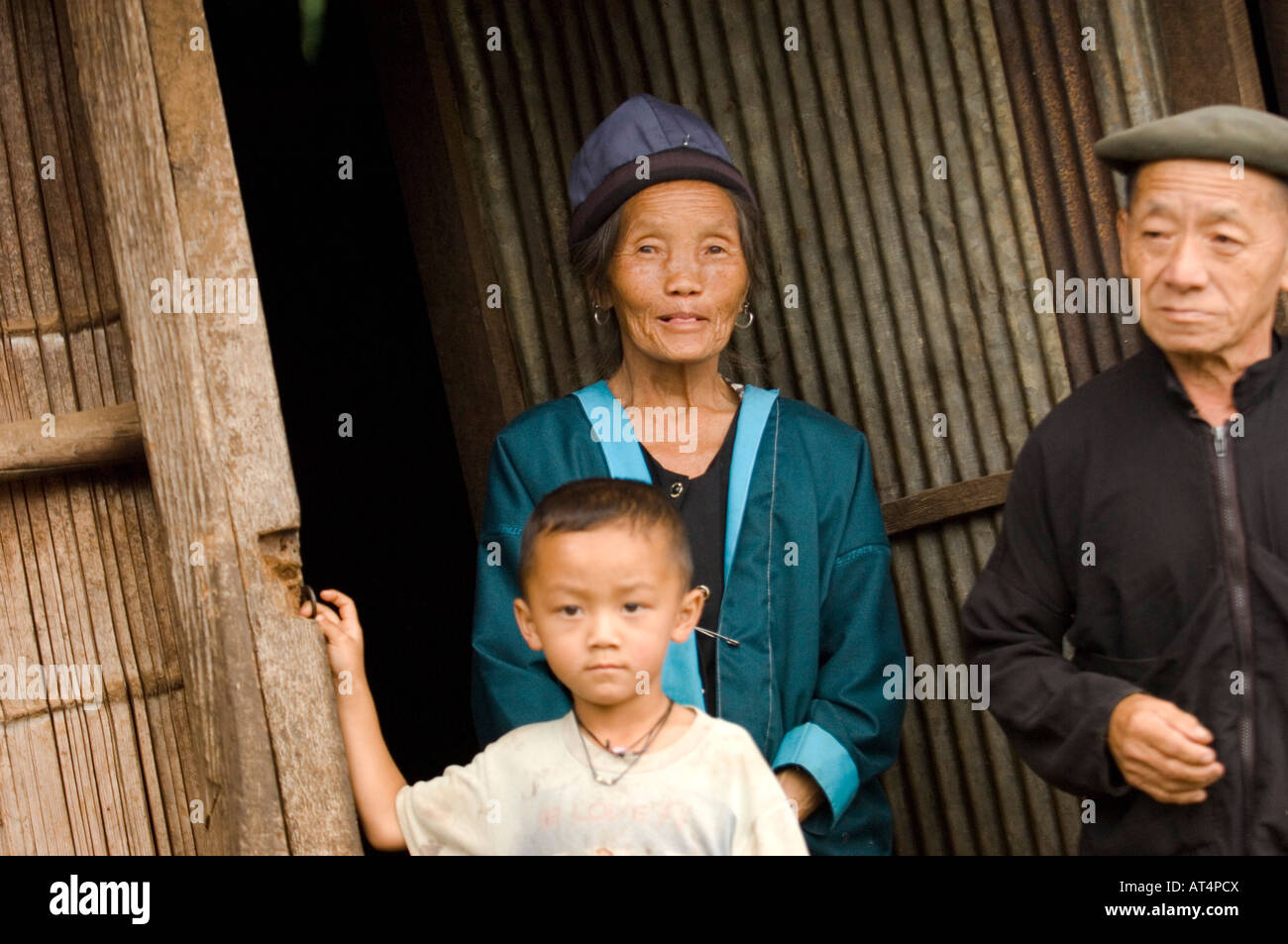 Woman man and boy outside a hut in the Hmong village Baan Pha Nok Kok ...