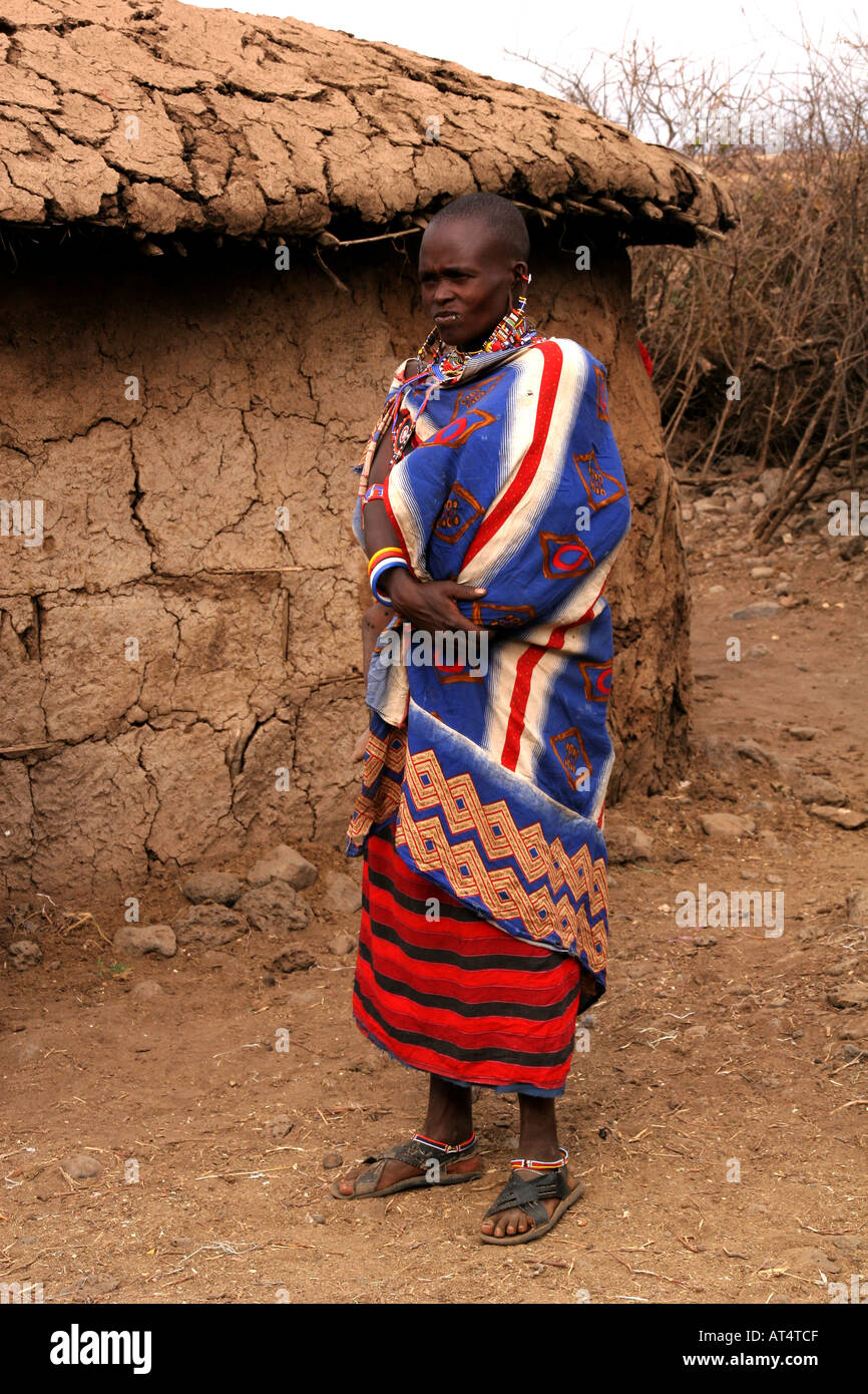 A portrait of a Maasai woman, in blue and red tribal clothes, standing ...