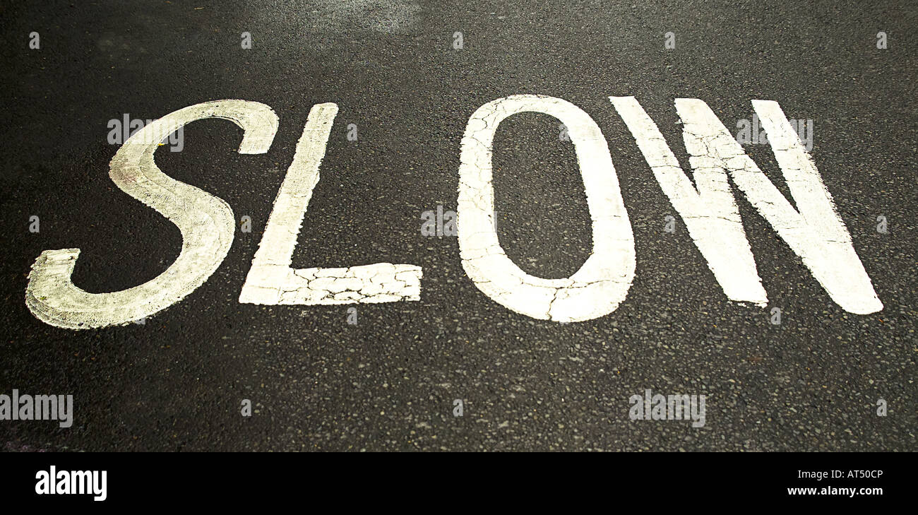 Slow sign painted onto tarmac Stock Photo - Alamy