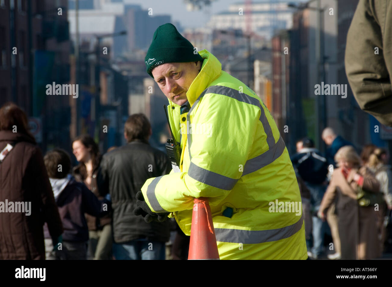 Bored looking male council worker leaning on orange cone during Chinese ...