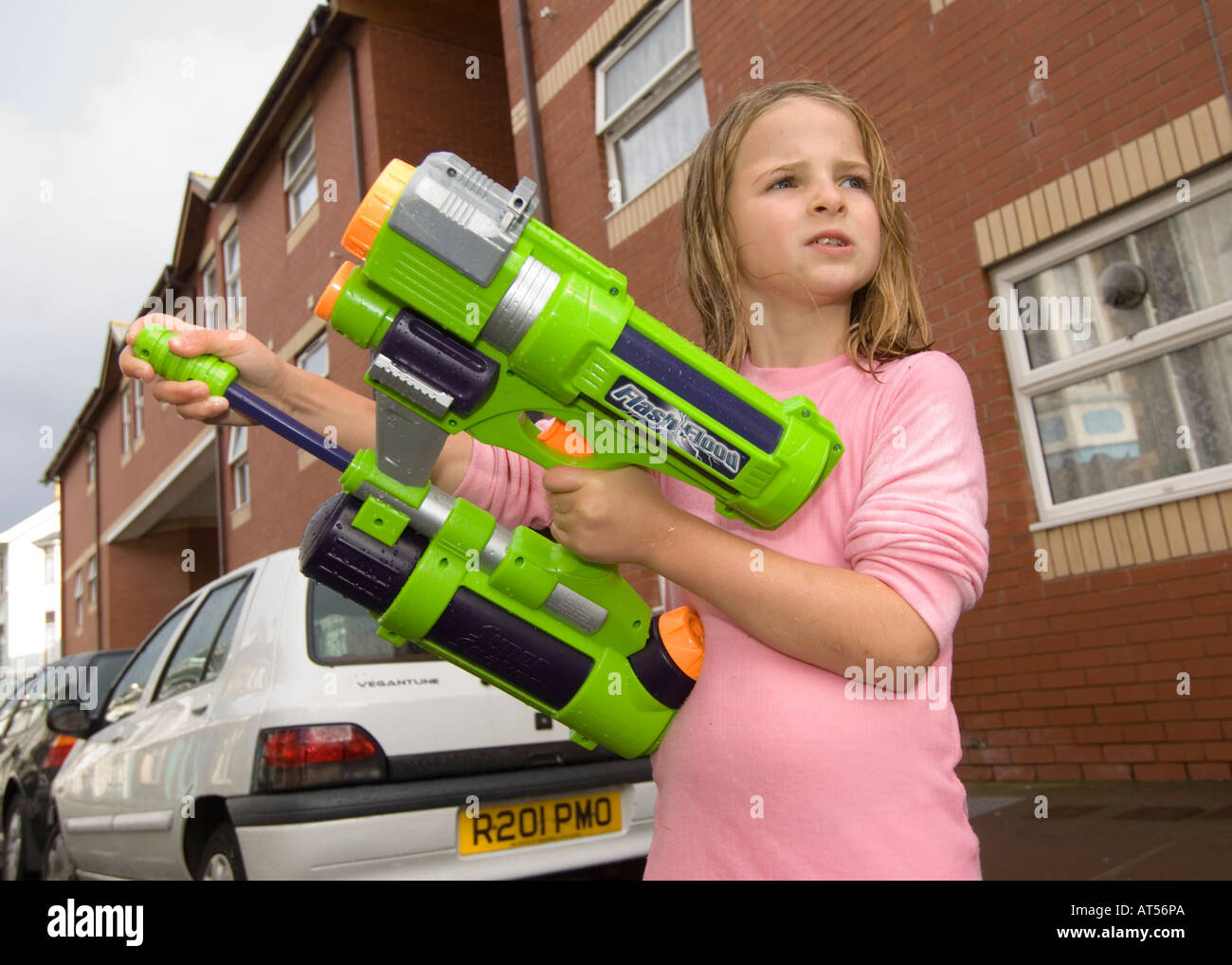 Young girl with enormous water pistol looking for her next target in a ...