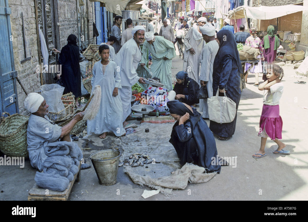 A busy street near the market in Luxor Egypt with arab trader sitting ...