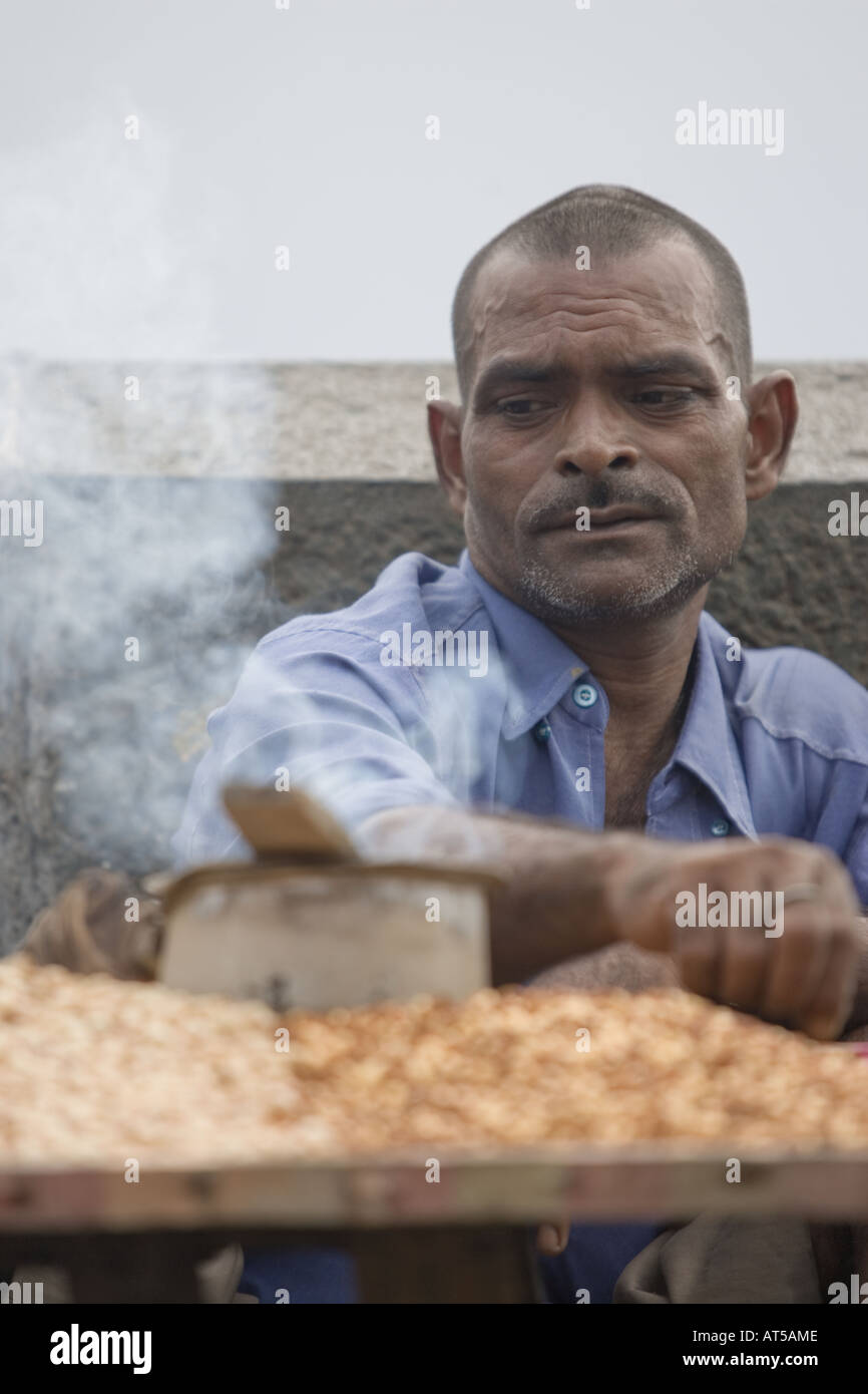 Man selling roasted peanuts Stock Photo - Alamy
