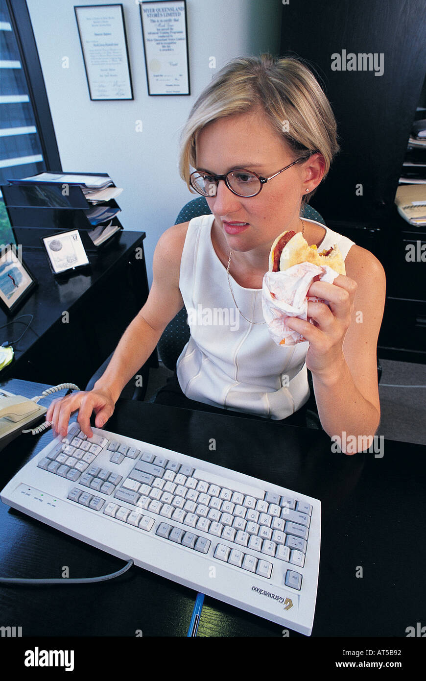 woman eating at computer keyboard Stock Photo - Alamy