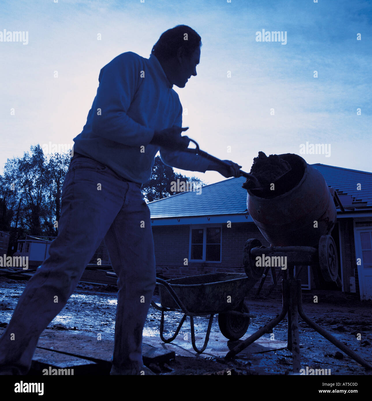 construction worker filling concrete mixer on building site Stock Photo ...
