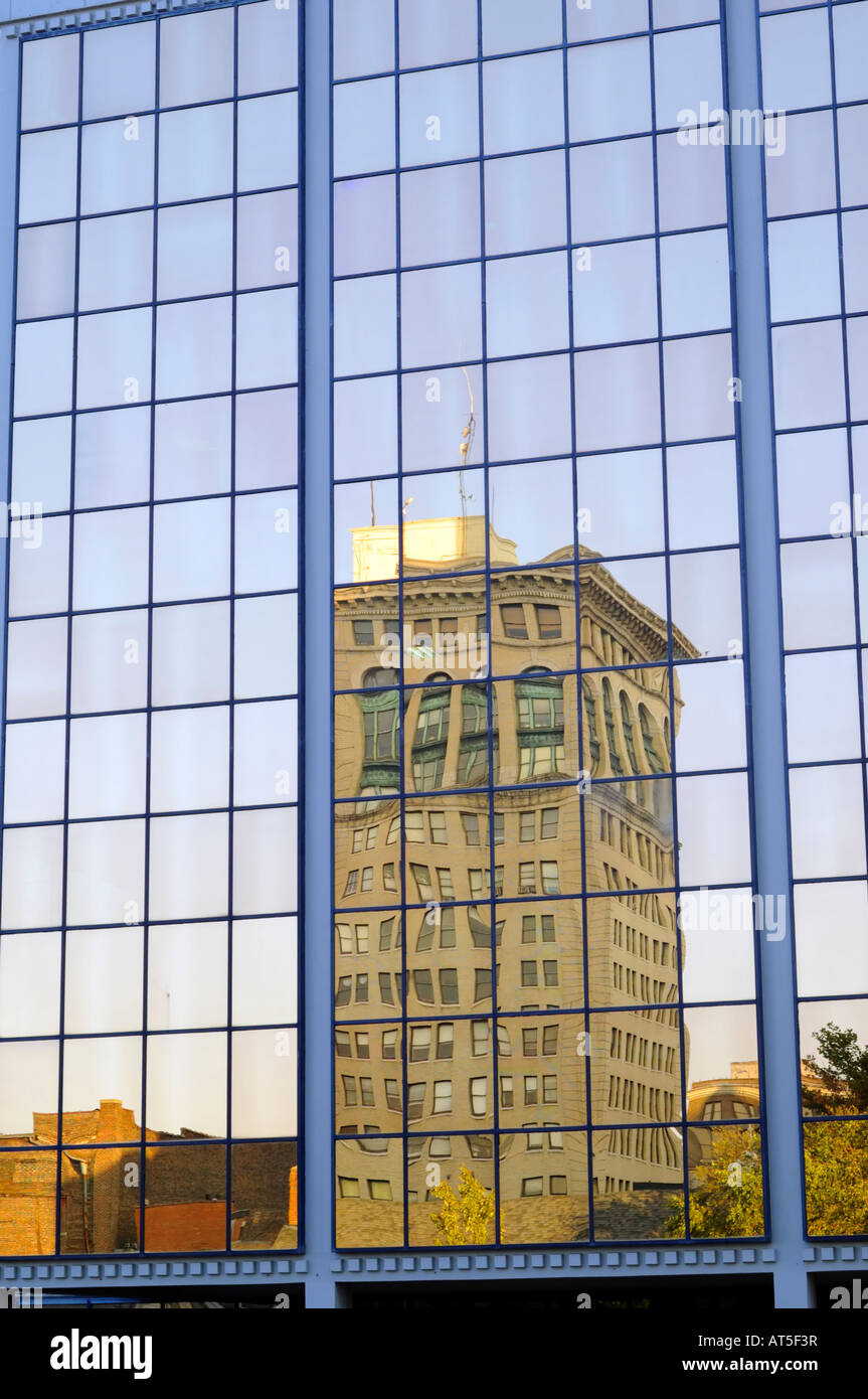 Distorted reflections of adjacent buildings in the glass window panes ...