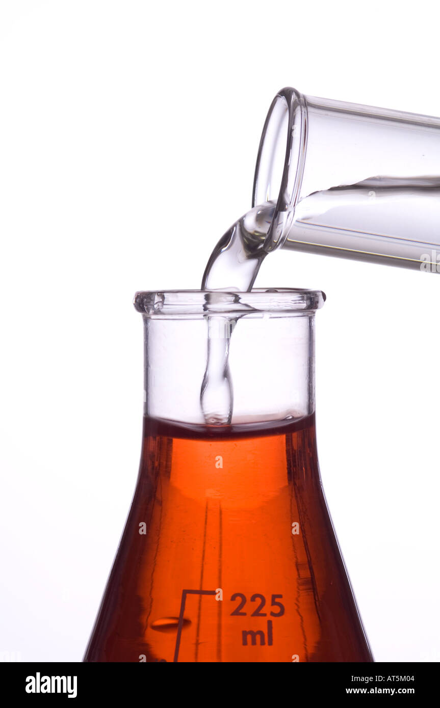 closeup view of liquid being poured from test tube into Erlenmeyer ...