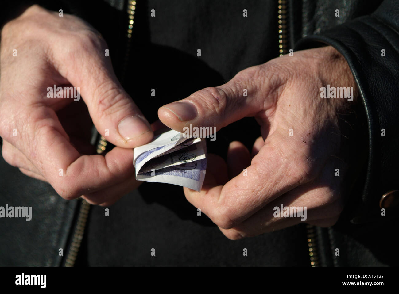 Hands folding a twenty pound note Stock Photo - Alamy