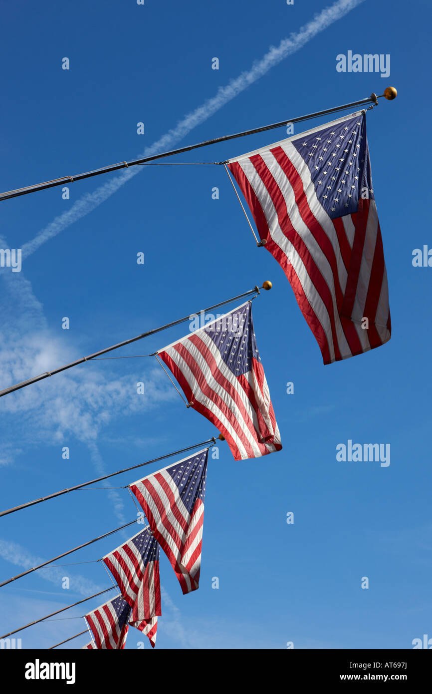 A view from below of USA national flags against blue sky. New Orleans ...