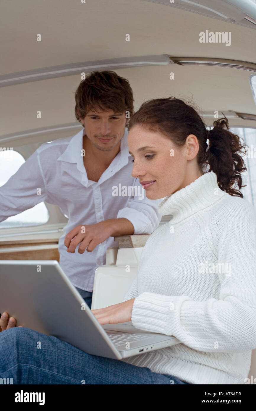 Germany, Baltic Sea, Lübecker Bucht, Young woman using laptop on ...