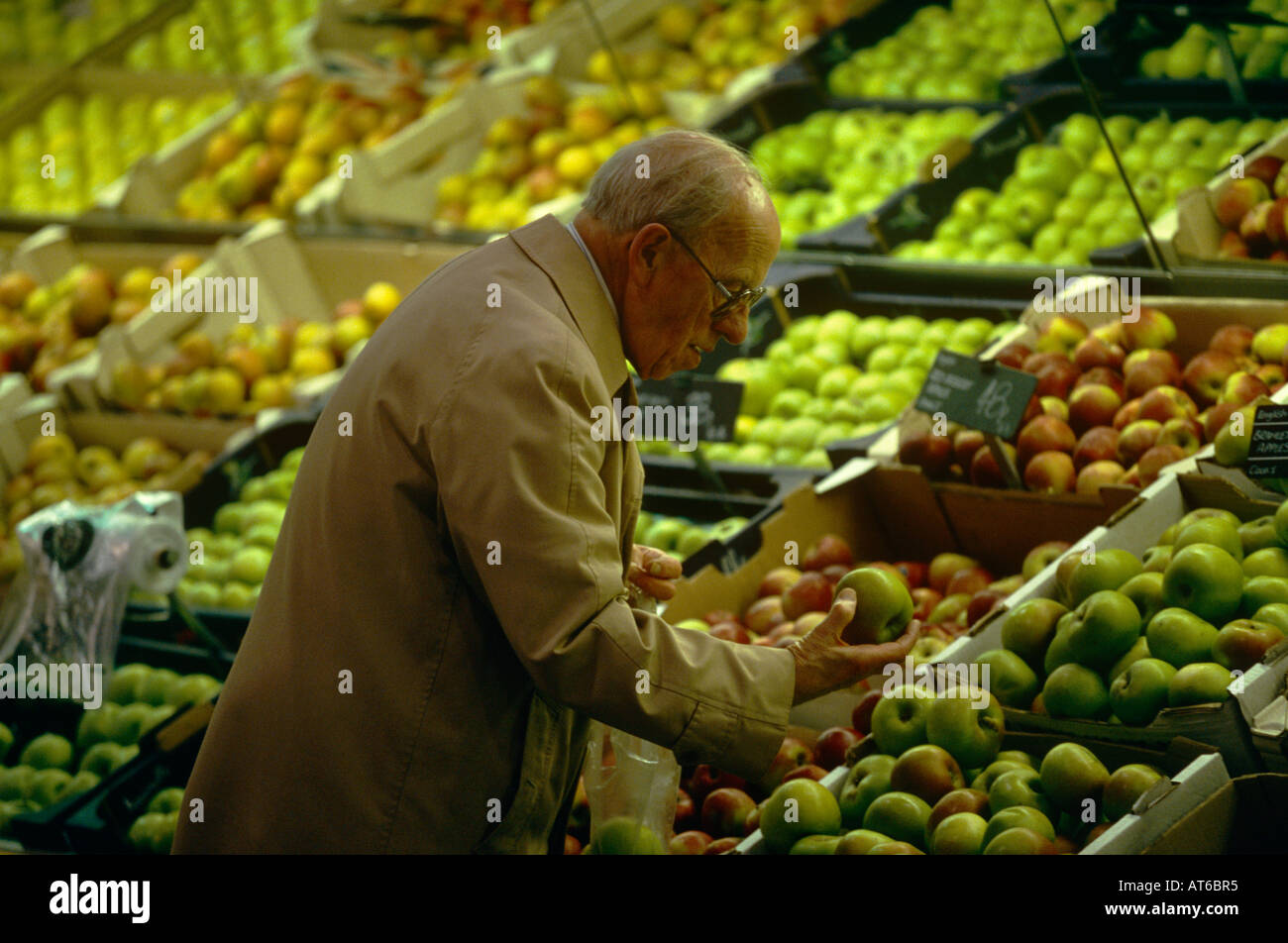 A man looking at apples in the fruit and vegetable section of an ASDA ...