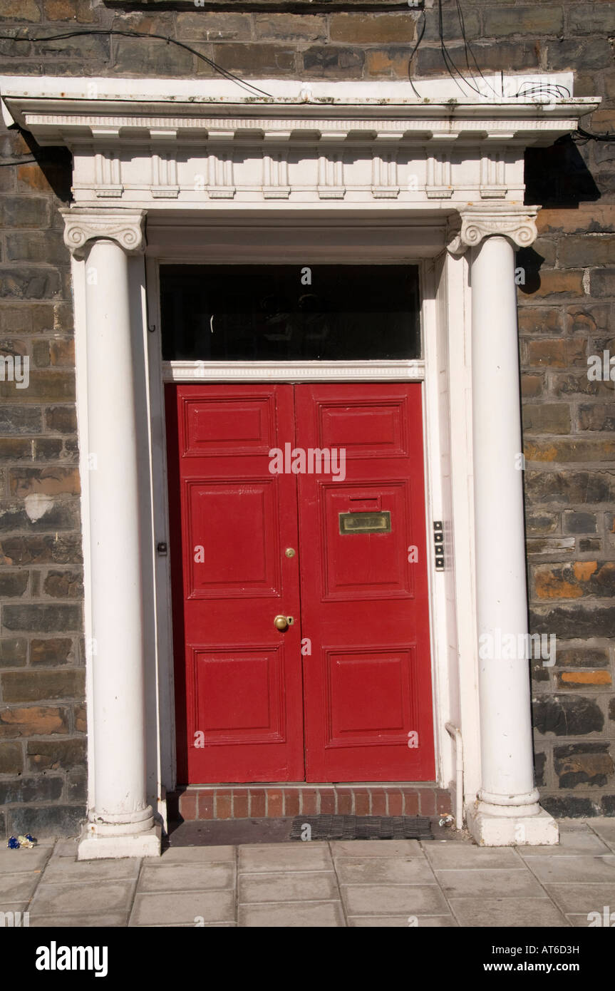 red painted wooden double front door with columns and portico on a ...