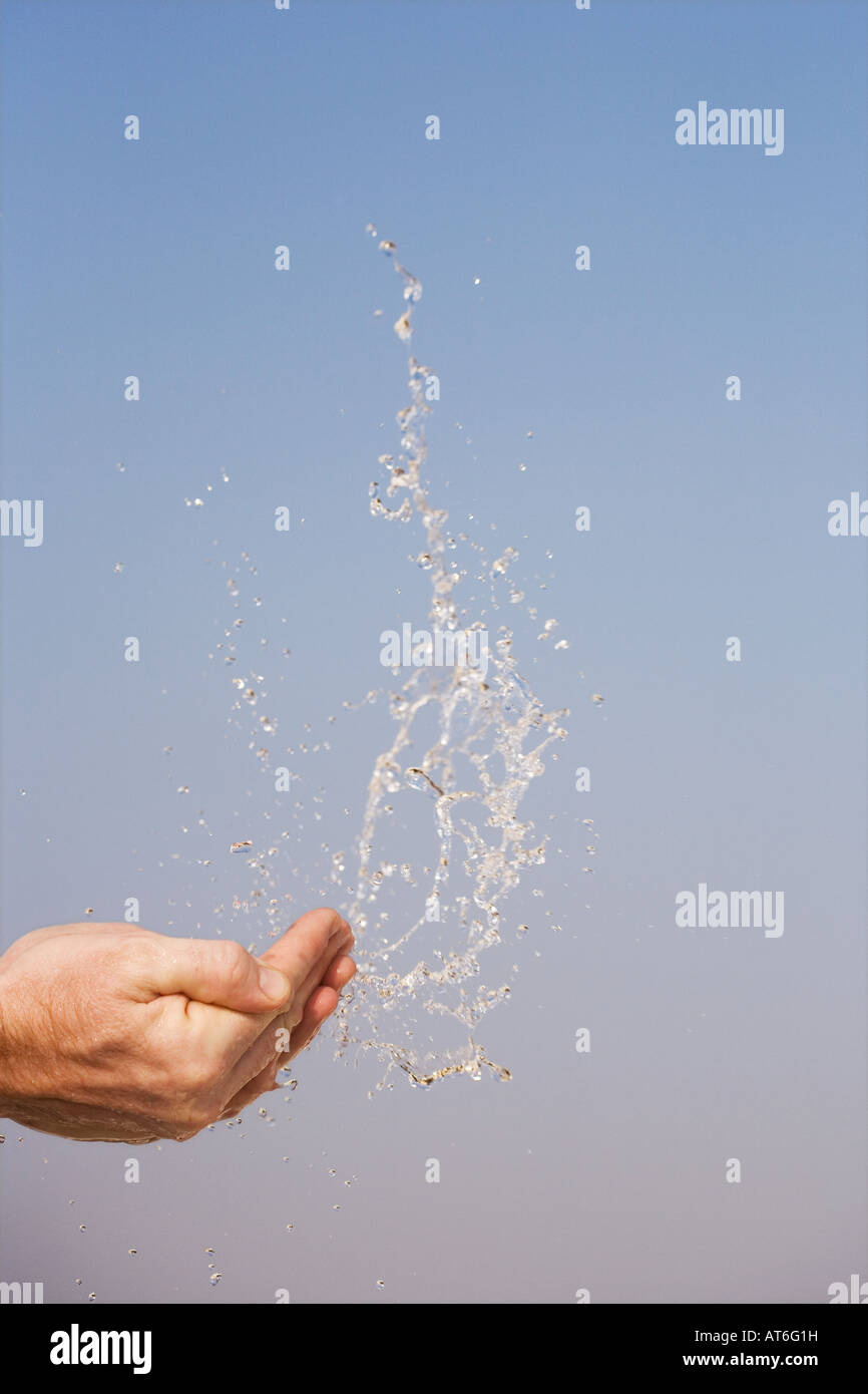 Water being thrown into the air from hands against a blue sky Stock ...