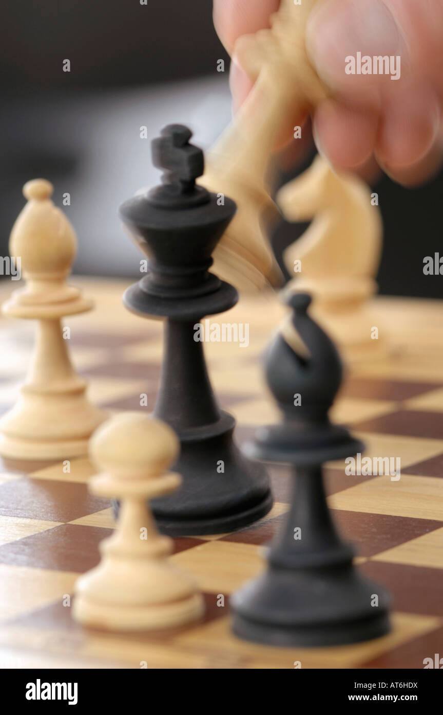 Man moving chess piece on chessboard Stock Photo - Alamy