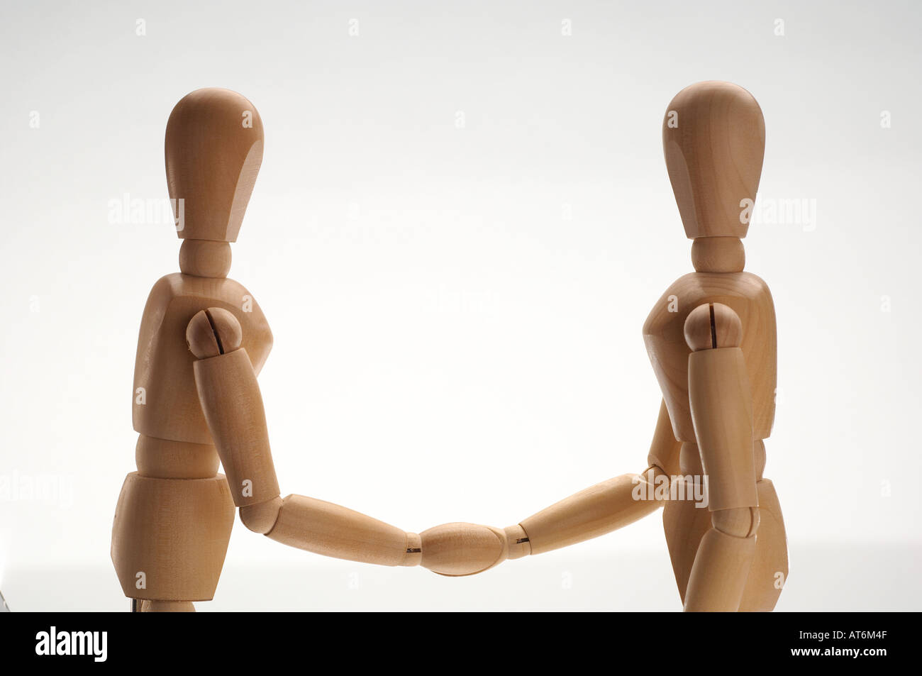 Carved wooden figures with hand shake Stock Photo - Alamy