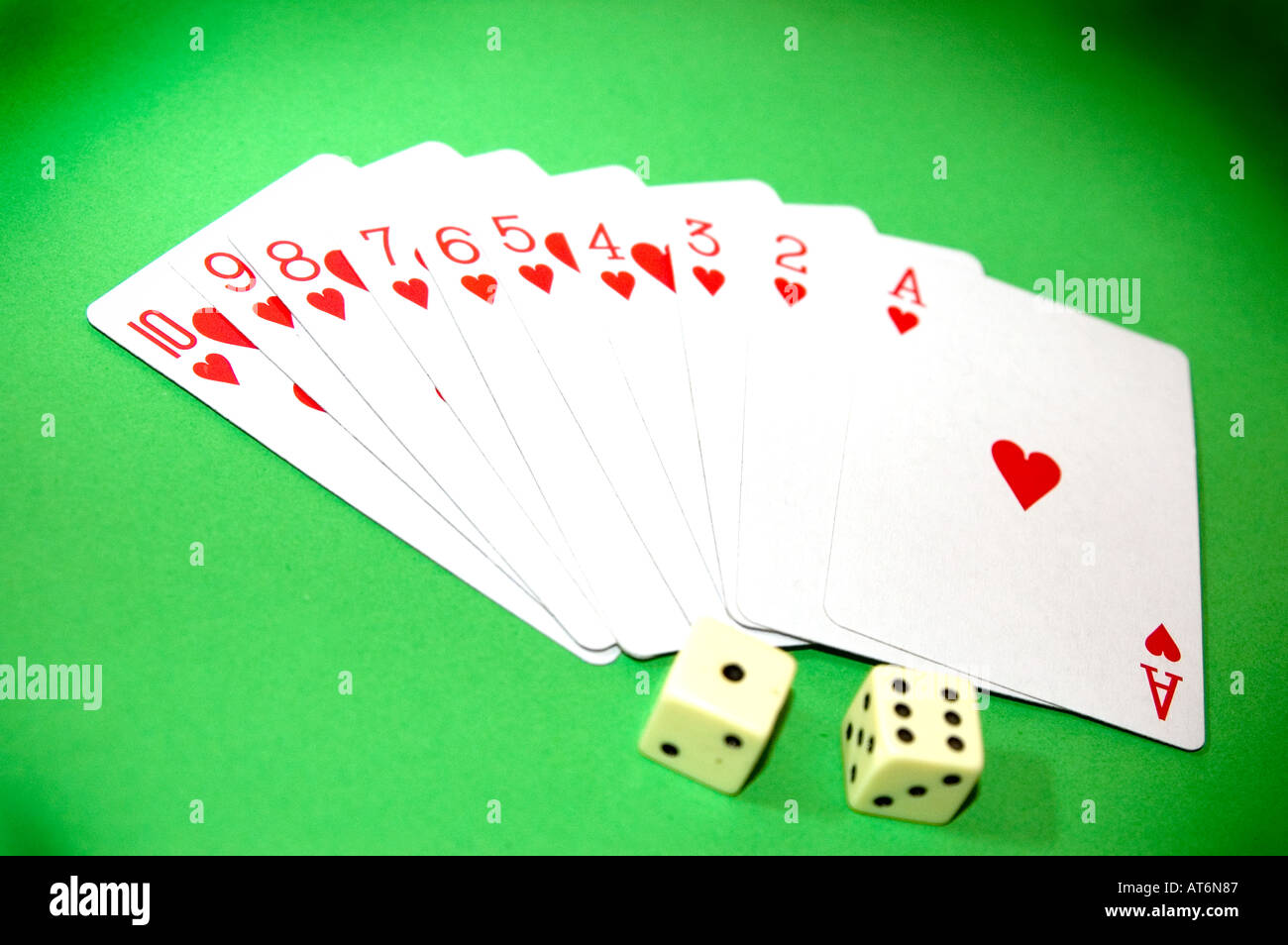 Deck of cards spread open on a table with dice beneath Stock Photo - Alamy