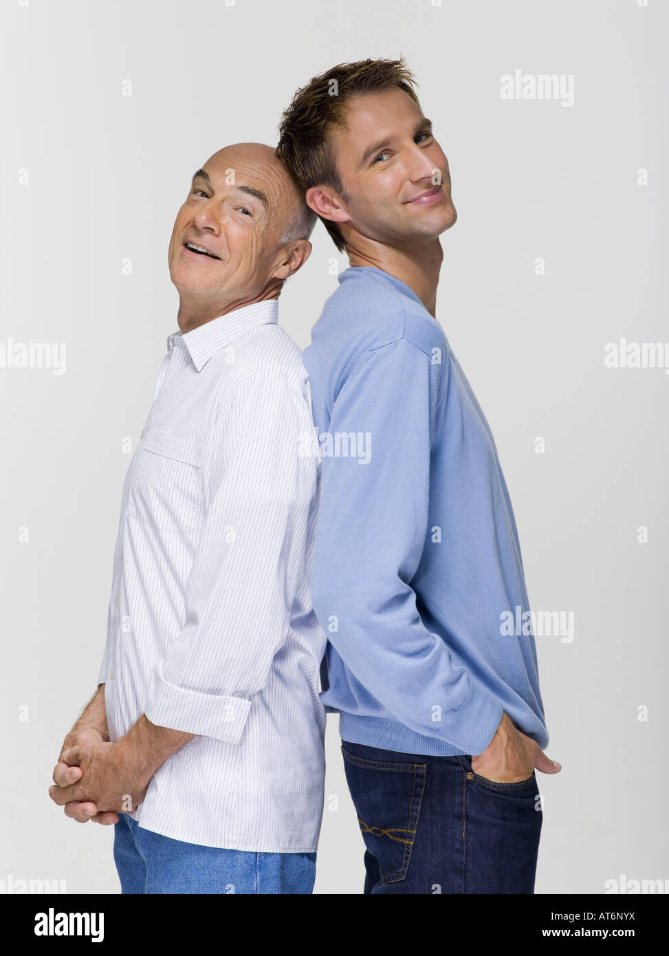 Mature father and son standing back to back, portrait Stock Photo - Alamy