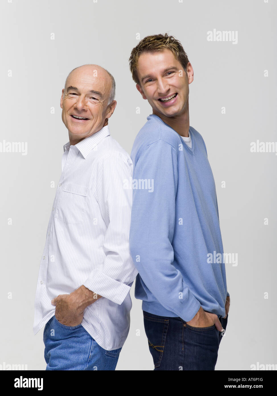 Mature father and son standing back to back, portrait Stock Photo - Alamy