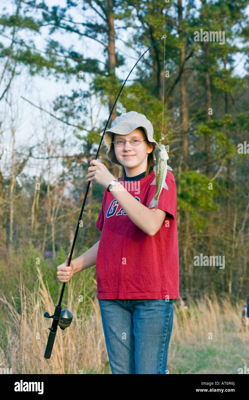 A girl fishing with rod and reel holding her catch Stock Photo - Alamy
