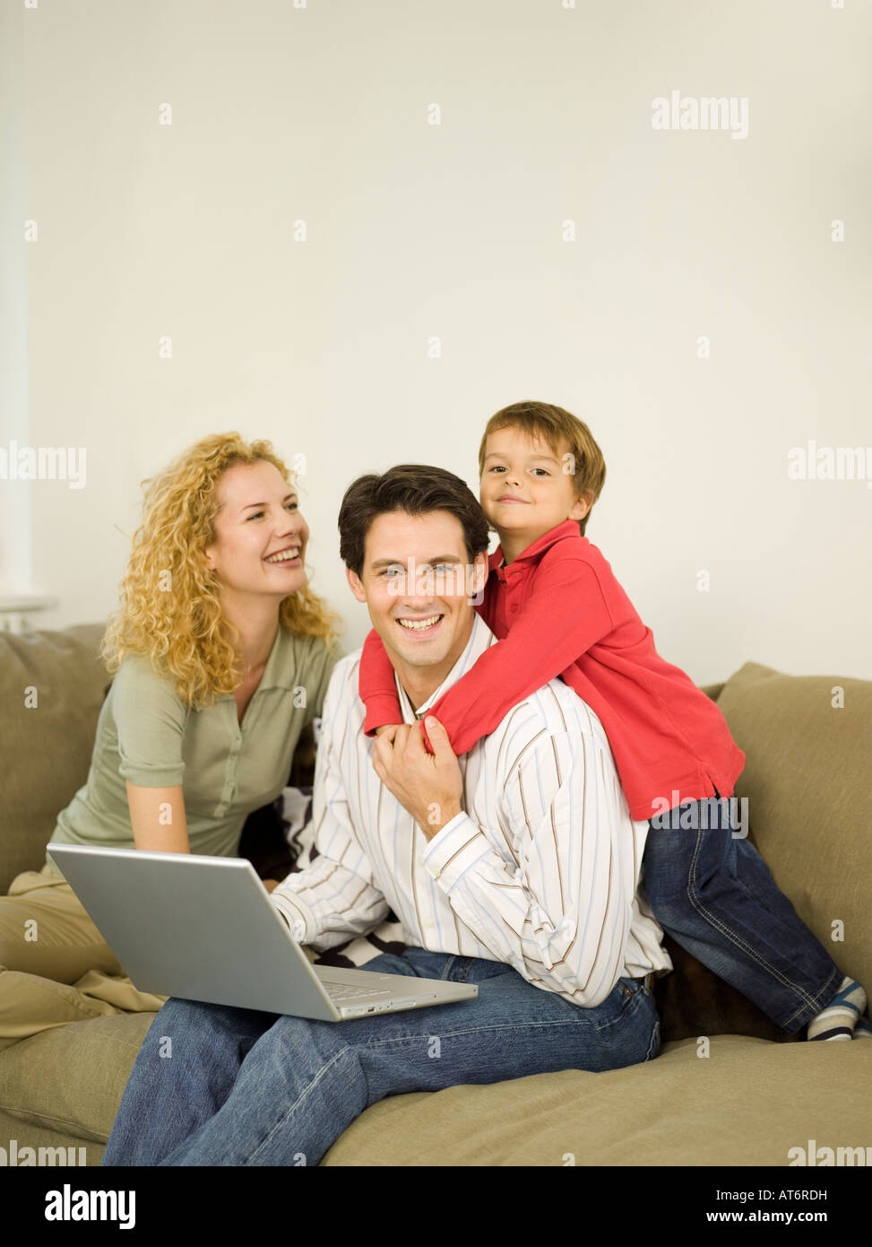 Young family in living room, father using laptop Stock Photo - Alamy