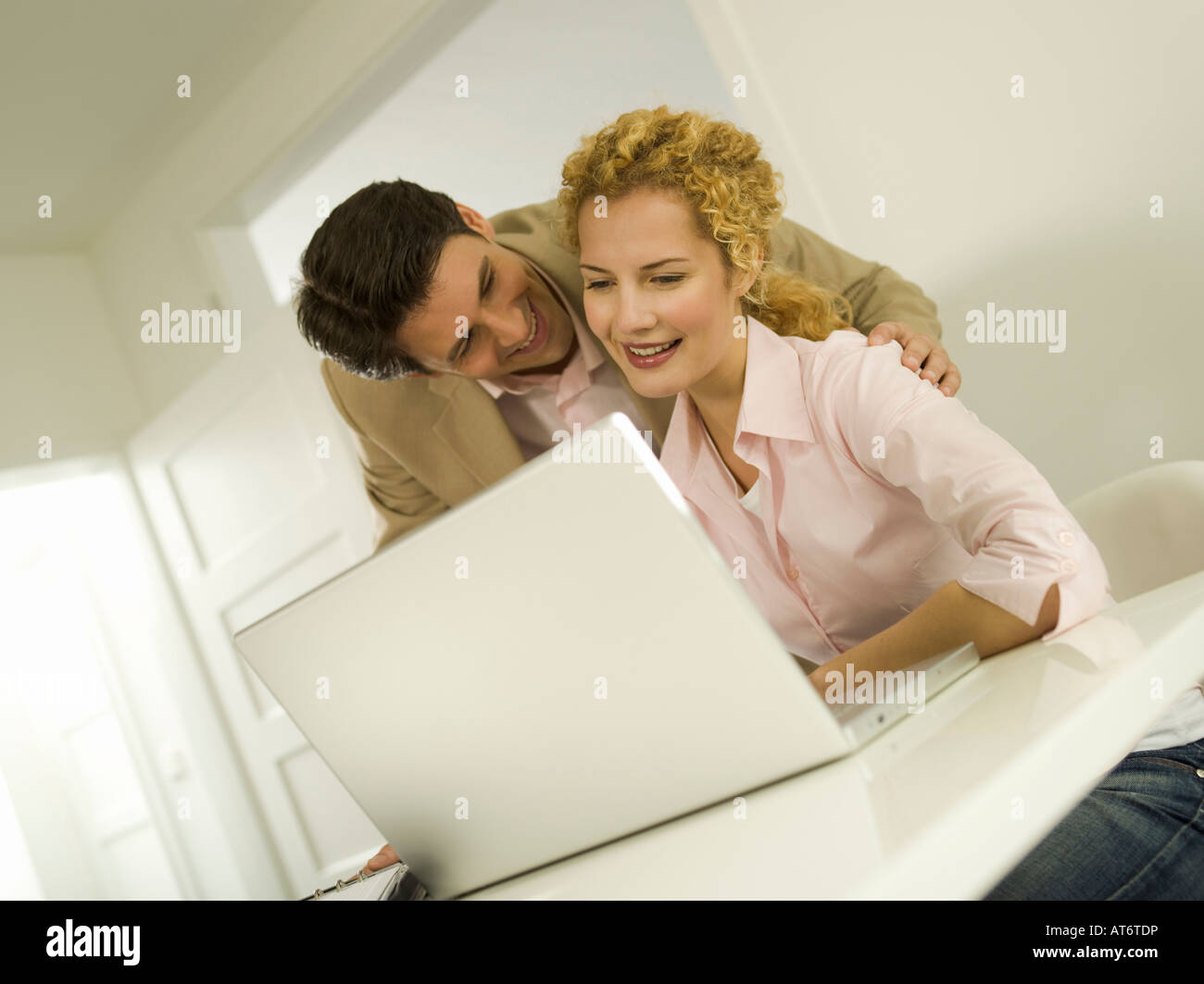 Young couple using laptop, smiling Stock Photo - Alamy