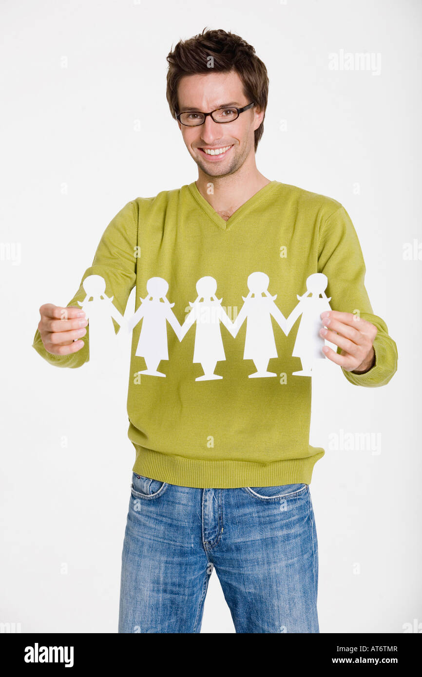 Young man holding paper cutouts, portrait Stock Photo - Alamy