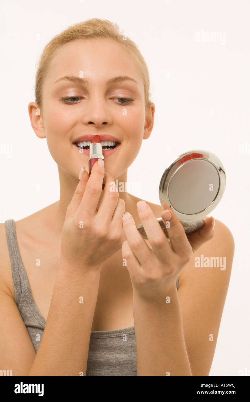 Young woman painting lips, portrait Stock Photo - Alamy
