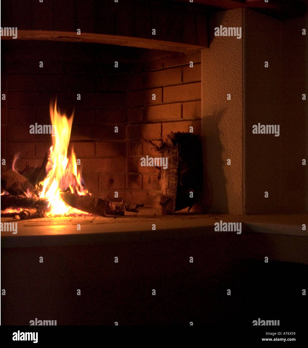 An inviting roaring wood fire burns in a traditional Greek fireplace ...