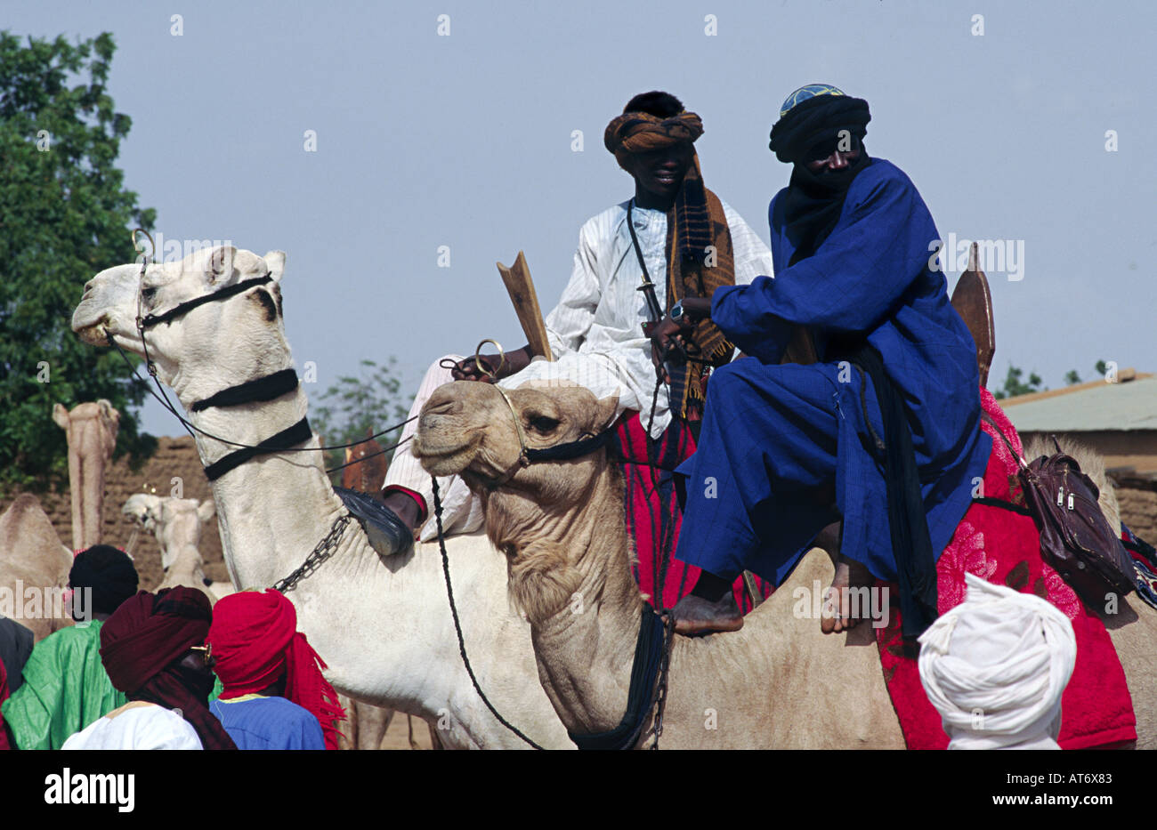 Two Tuareg men in traditional desert clothing arriving at a livestock ...
