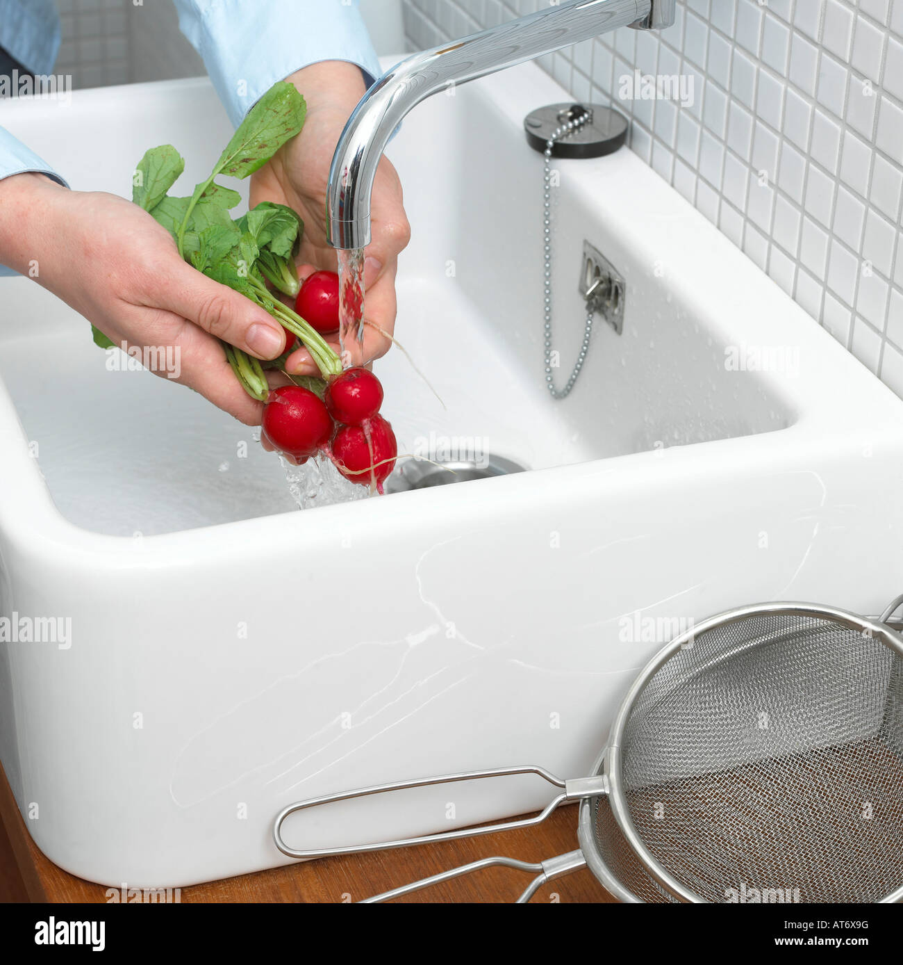 Hand's cleaning bunch of radish, close-up Stock Photo - Alamy